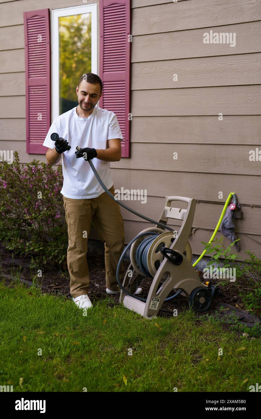 Adult watering garden hose flowers hi-res stock photography and images ...