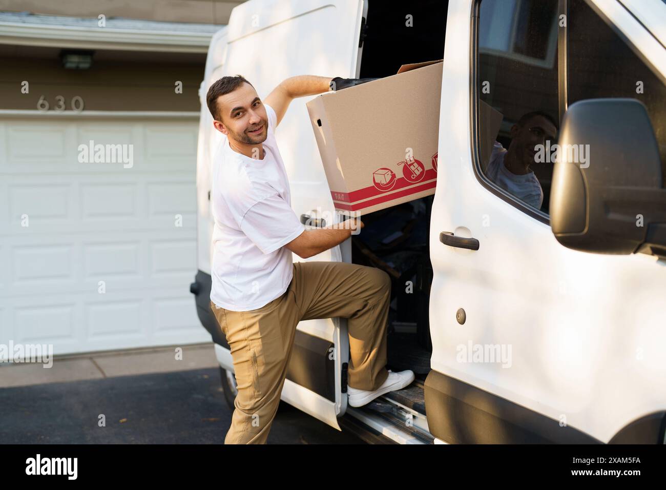 Young delivery men loading cardboard boxes from truck Stock Photo - Alamy
