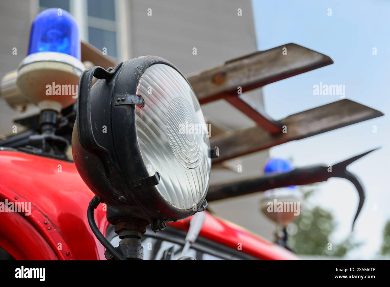 Detail of a red vintage fire engine with headlight, blue light, ladder ...
