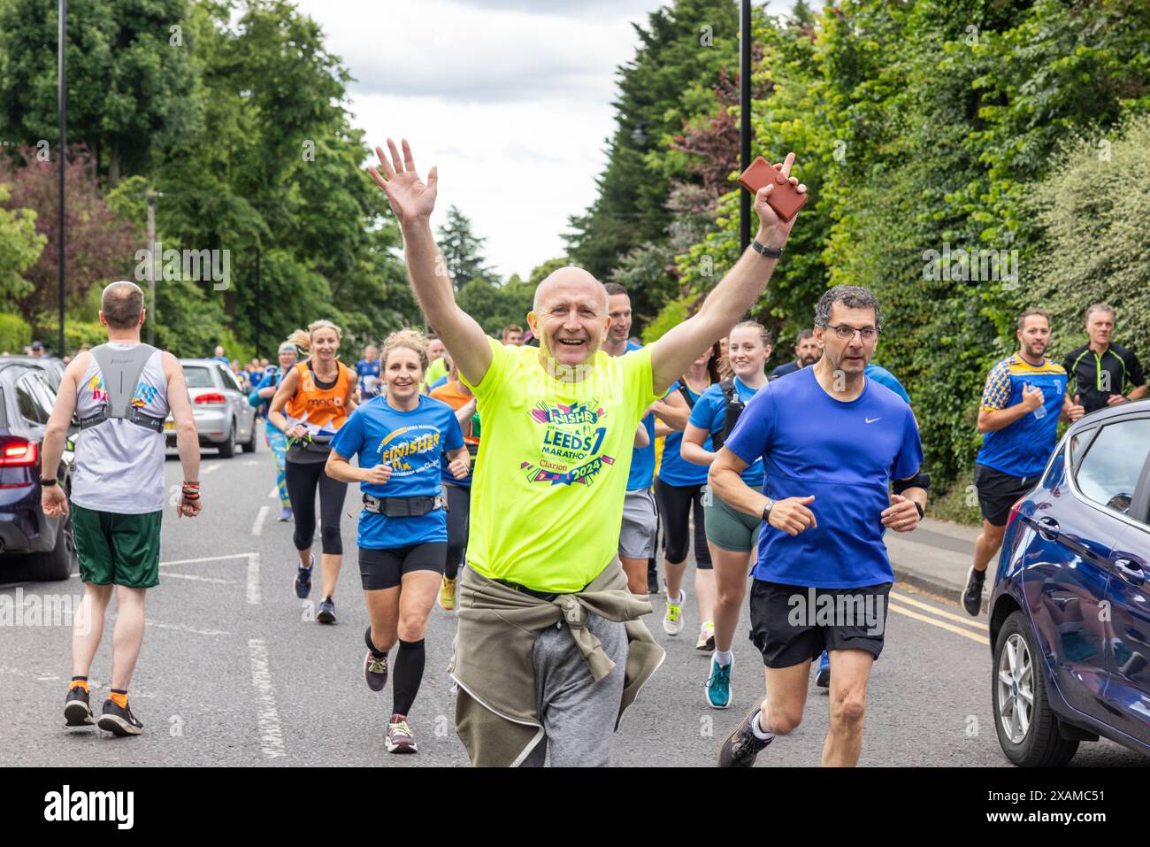 Leeds, UK. 07 JUN, 2024. Runner with arms raised looks at camera as ...