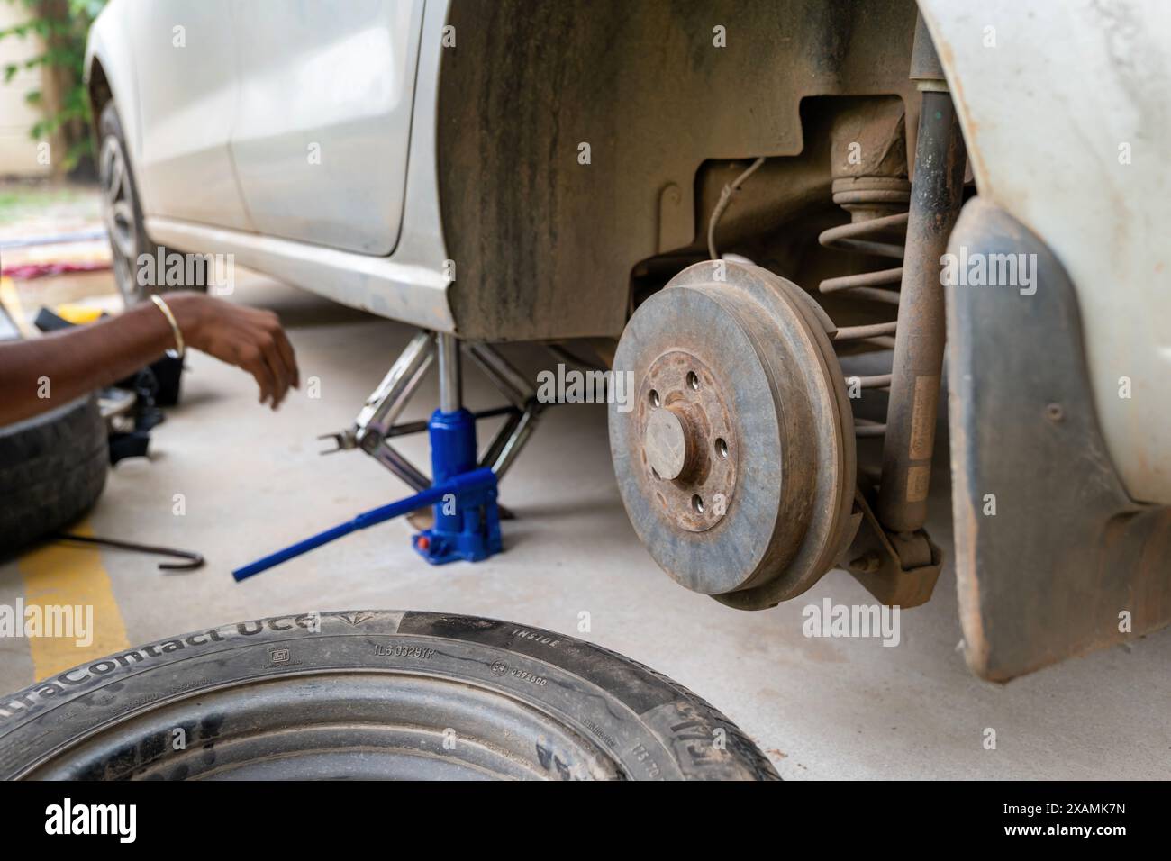 Focused driver demonstrates practical auto maintenance by changing a ...