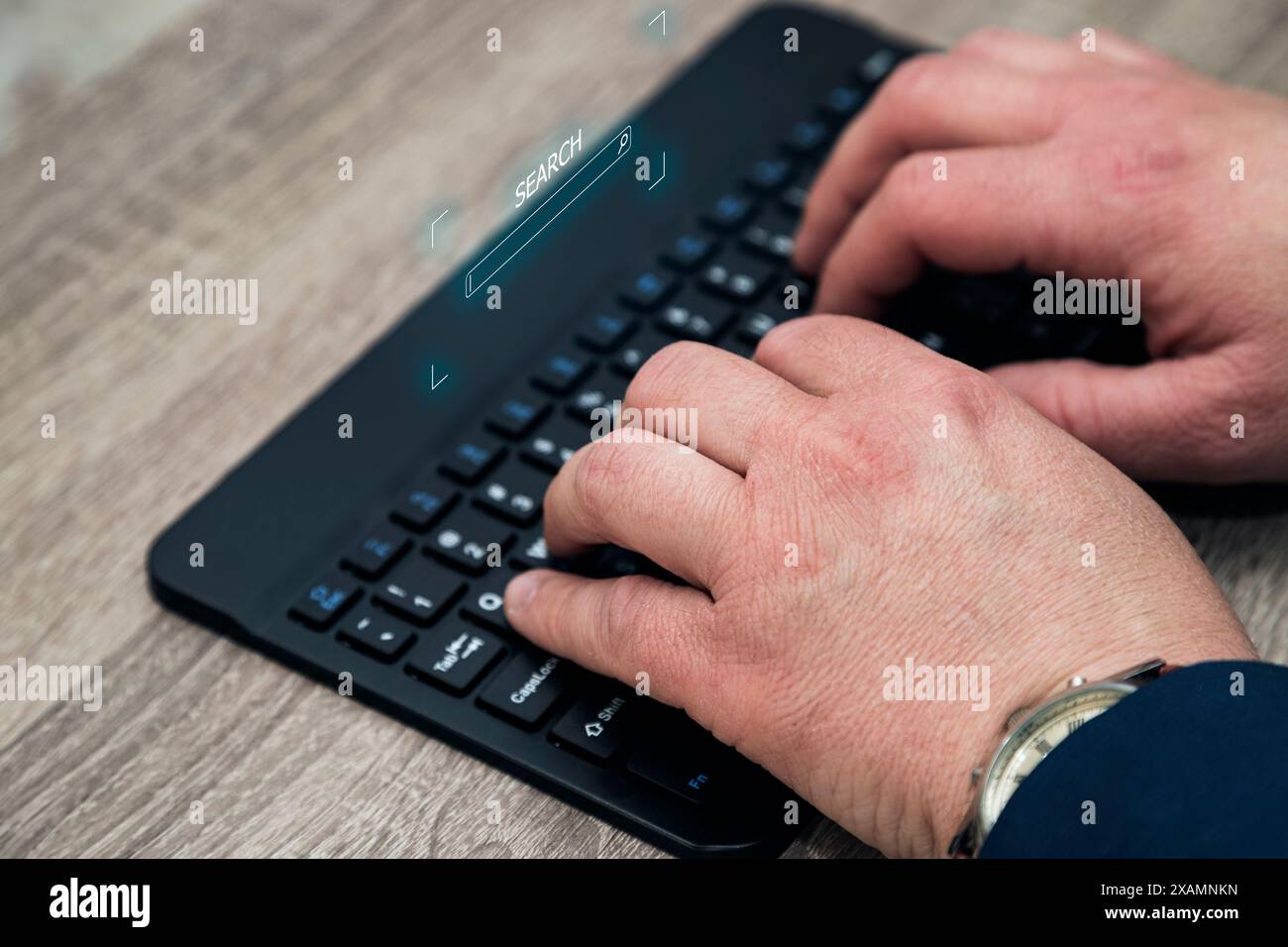 Unrecognizable caucasian man's hands typing in a computer keyboard while a virtual HUD appears ...