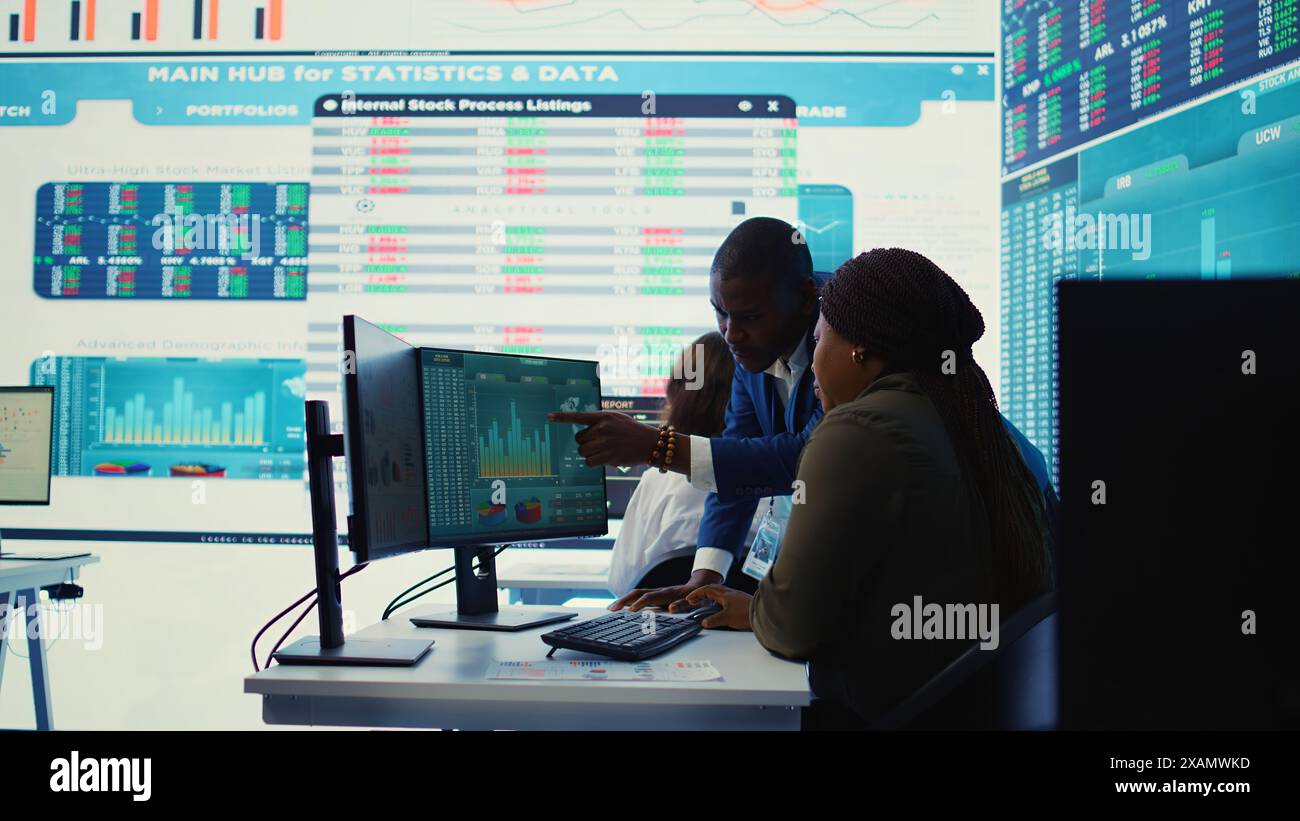 Financial analyst works on resource allocation plans with his staff, analyzing reports and sales ...