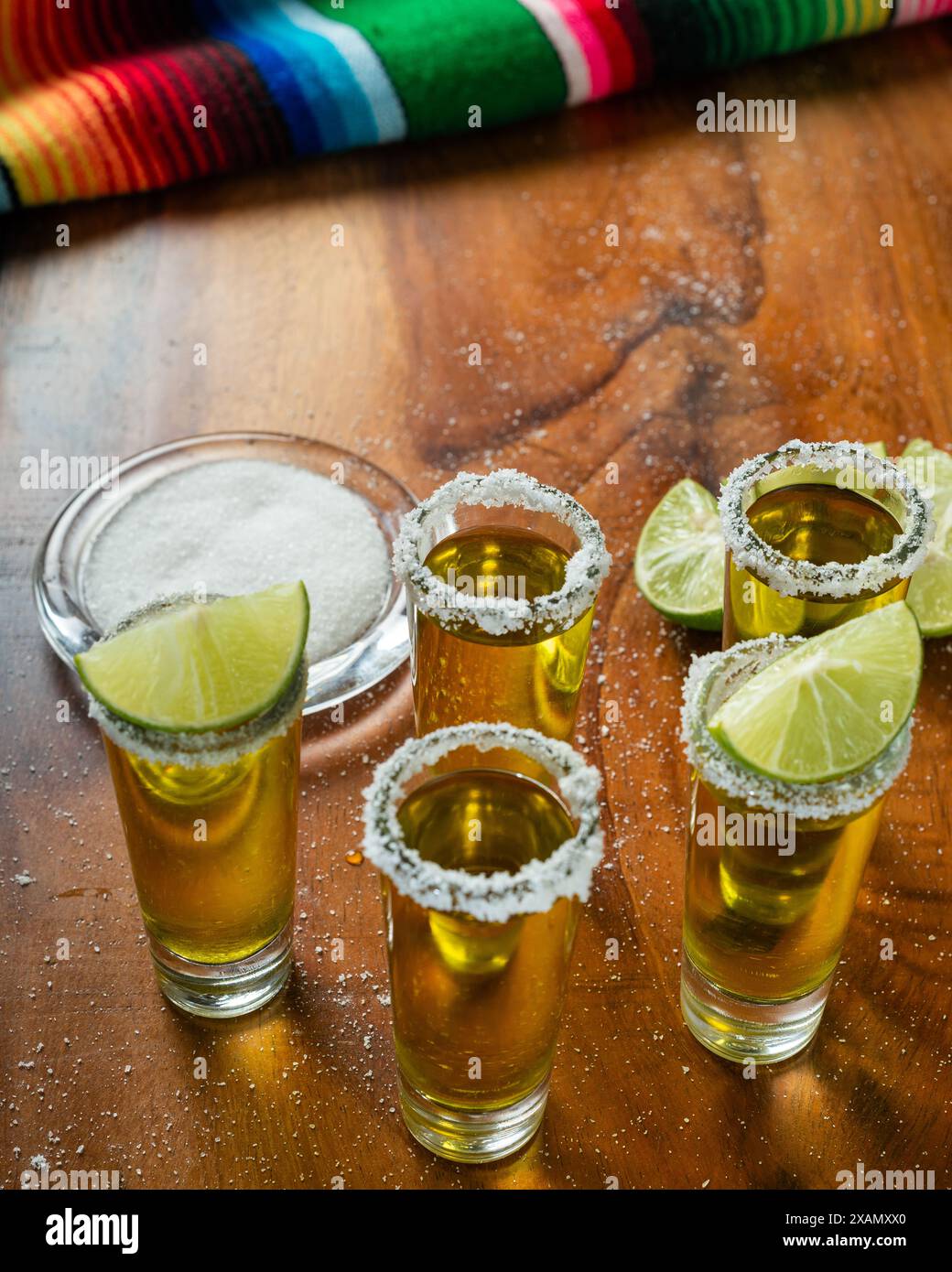 Shots of tequila with salt and lemon on a wooden table. Festive background cinco de mayo and ...