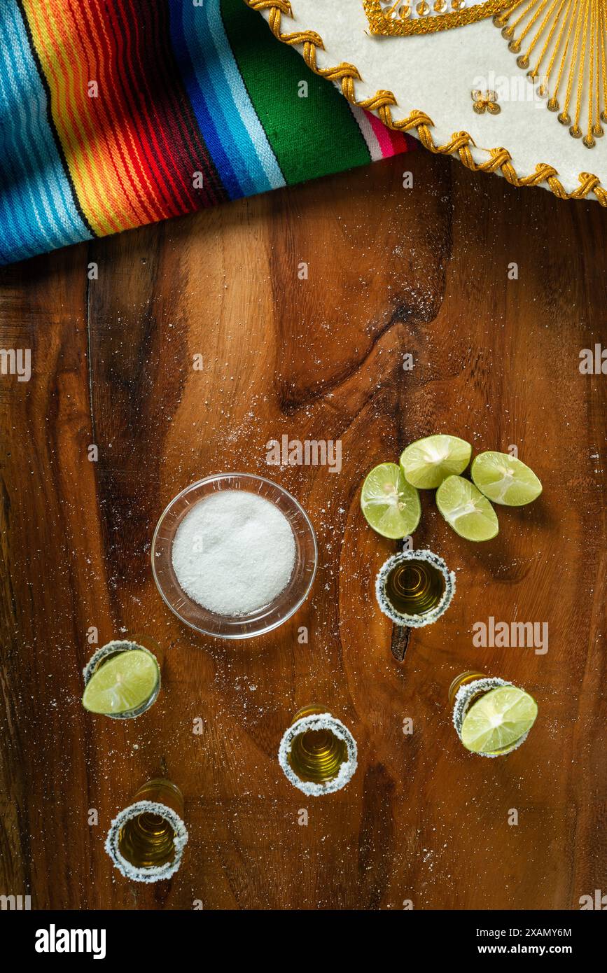 Shots of tequila with salt and lemon on a wooden table. Festive background cinco de mayo and ...