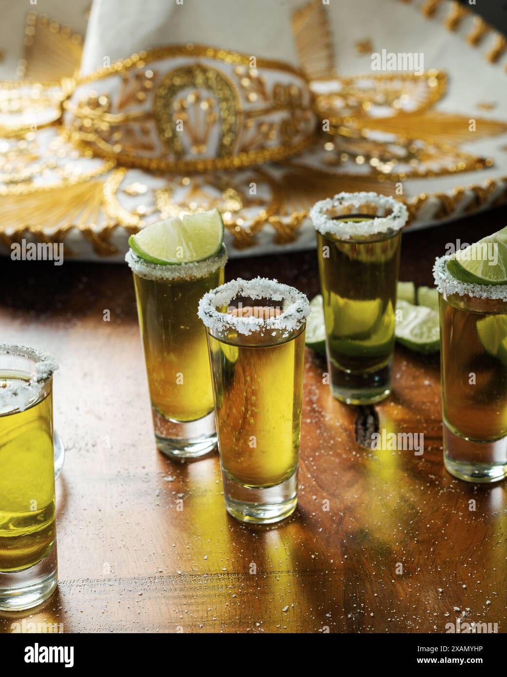 Shots of tequila with salt and lemon on a wooden table. Festive background cinco de mayo and ...