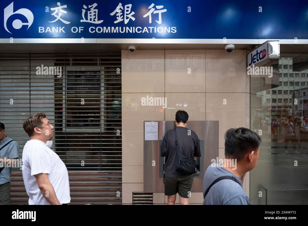 A customer withdraws money from an ATM at a Chinese Bank of ...