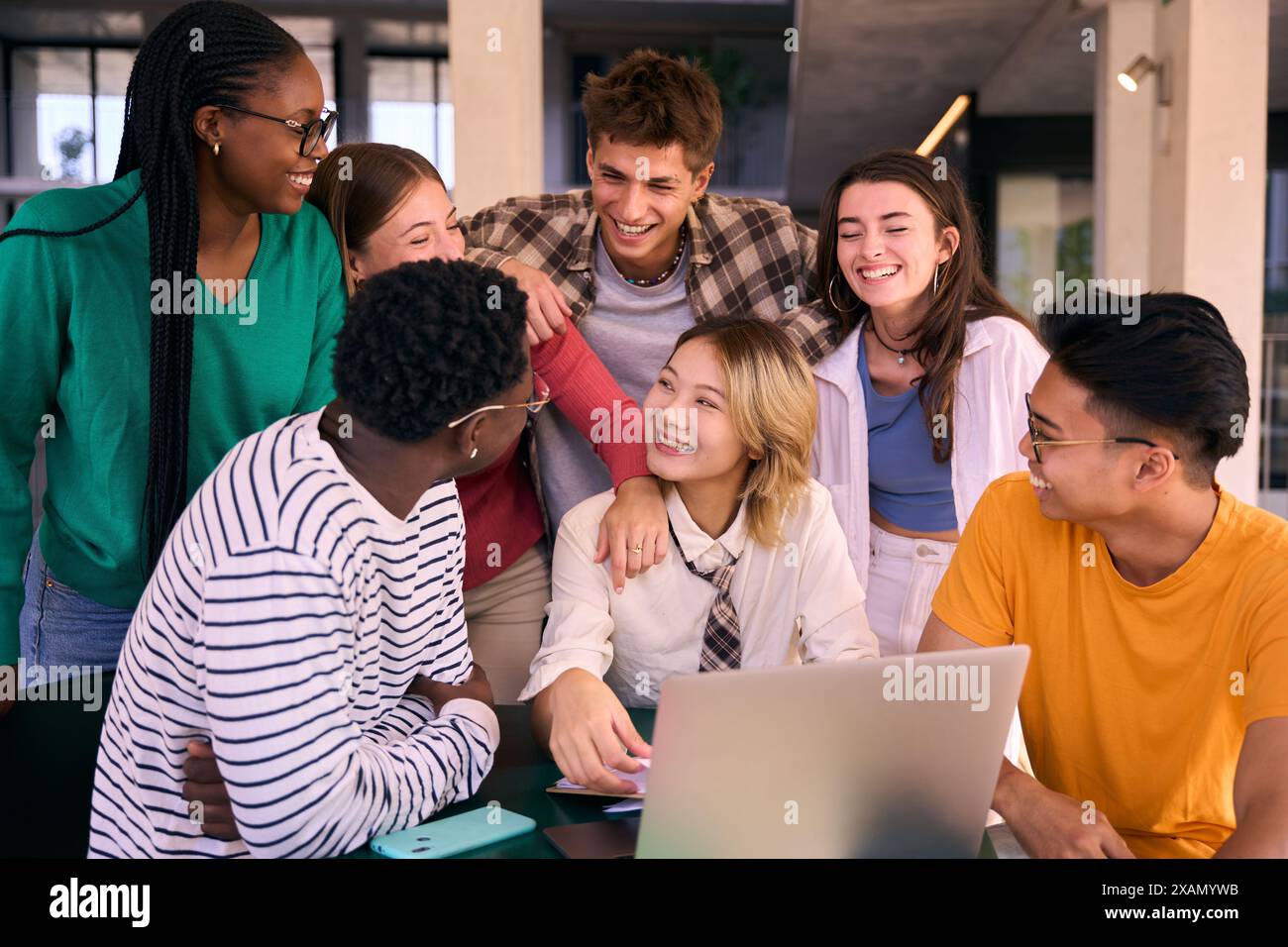 Group of young university students smiling using laptop computer at ...