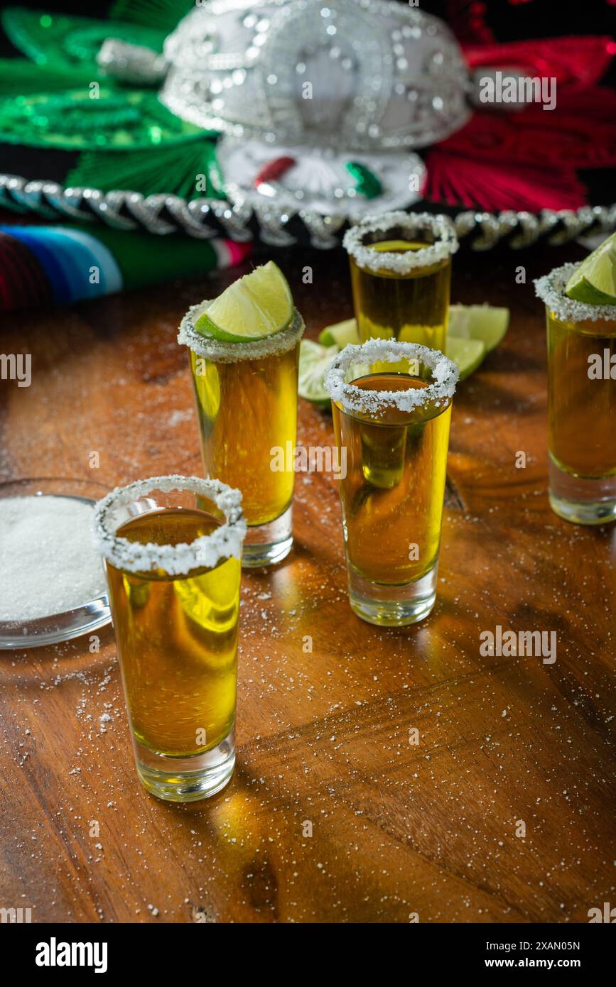 Shots of tequila with salt and lemon on a wooden table. Festive ...