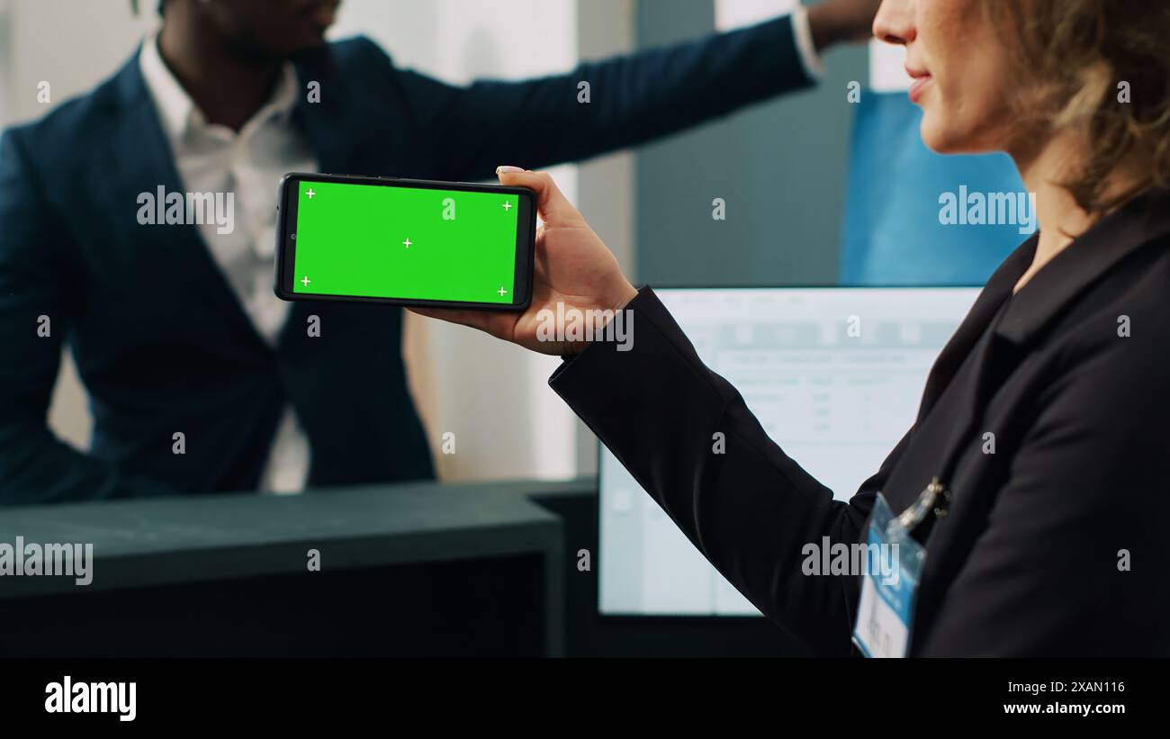 Store worker using smartphone with greenscreen template at cash ...