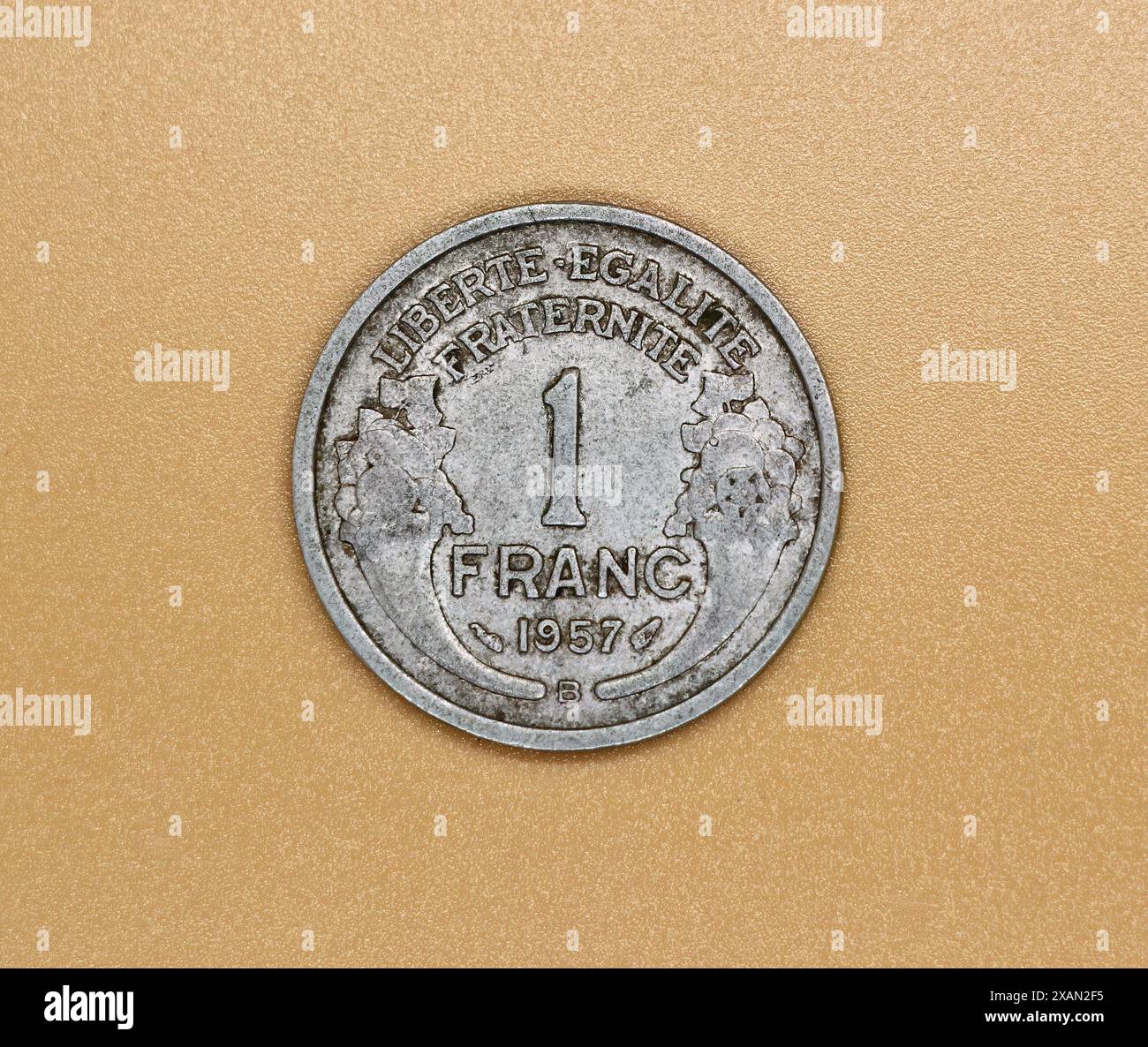 Photo close up of the reverse of a used and dirty 1957 French 1 franc ...