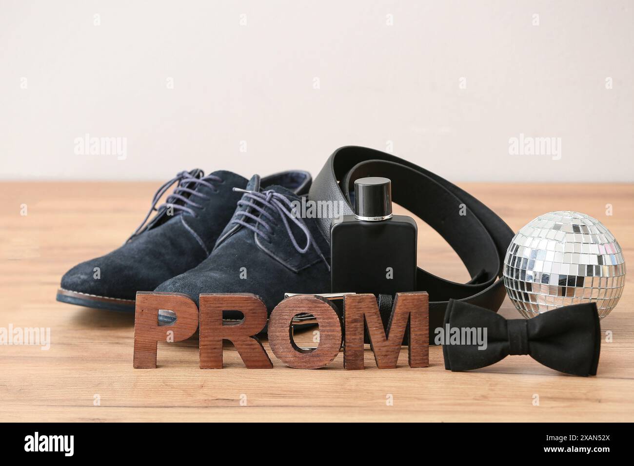 Word PROM with male shoes, belt and disco ball on wooden table against ...