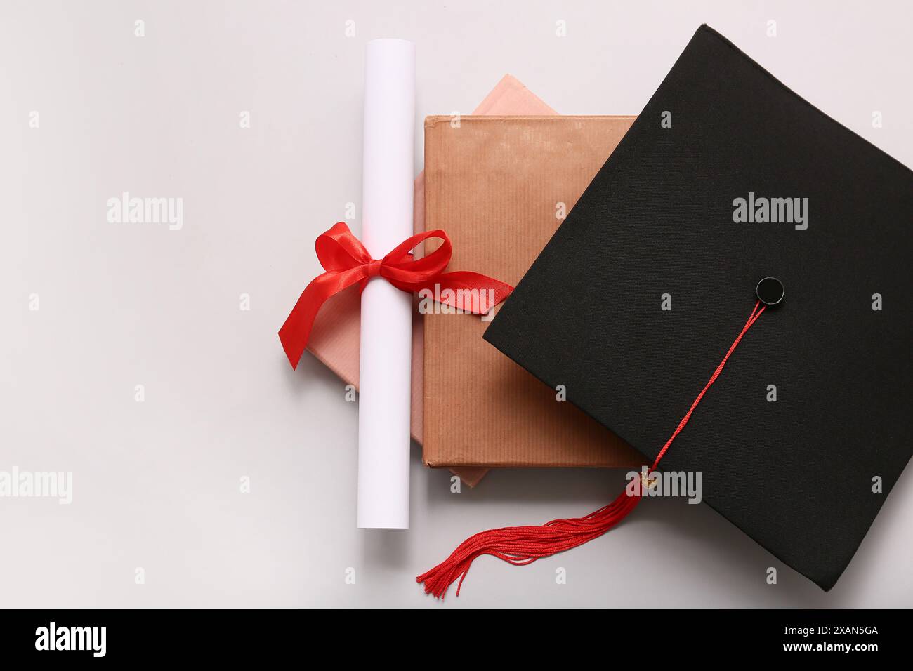 Diploma with red ribbon, books and graduation hat on white background ...