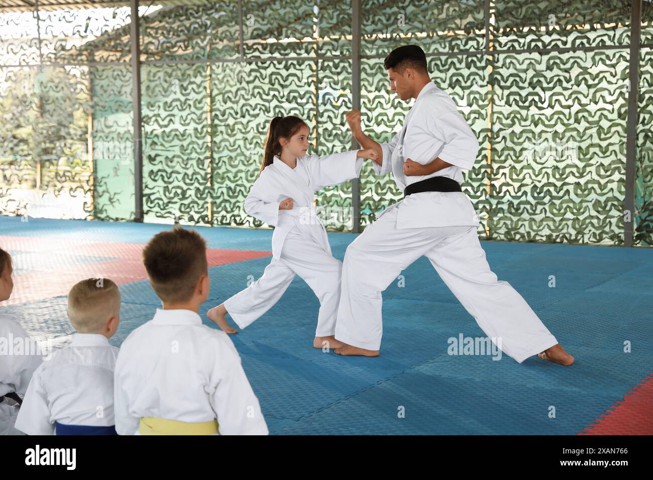 Girl practicing karate with coach on tatami outdoors Stock Photo - Alamy
