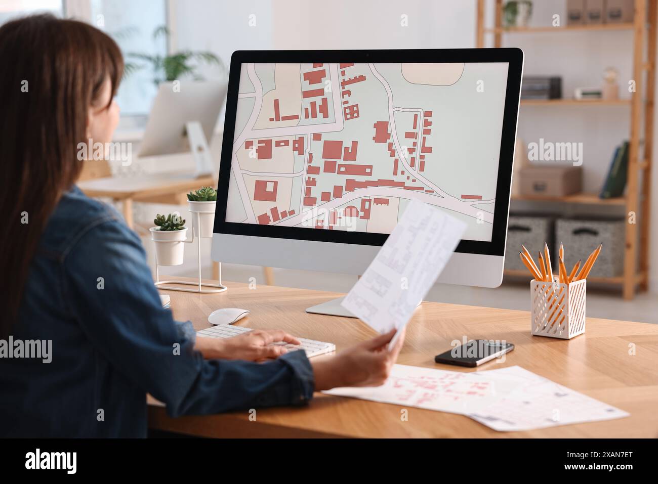 Cartographer working with cadastral maps at table in office Stock Photo ...