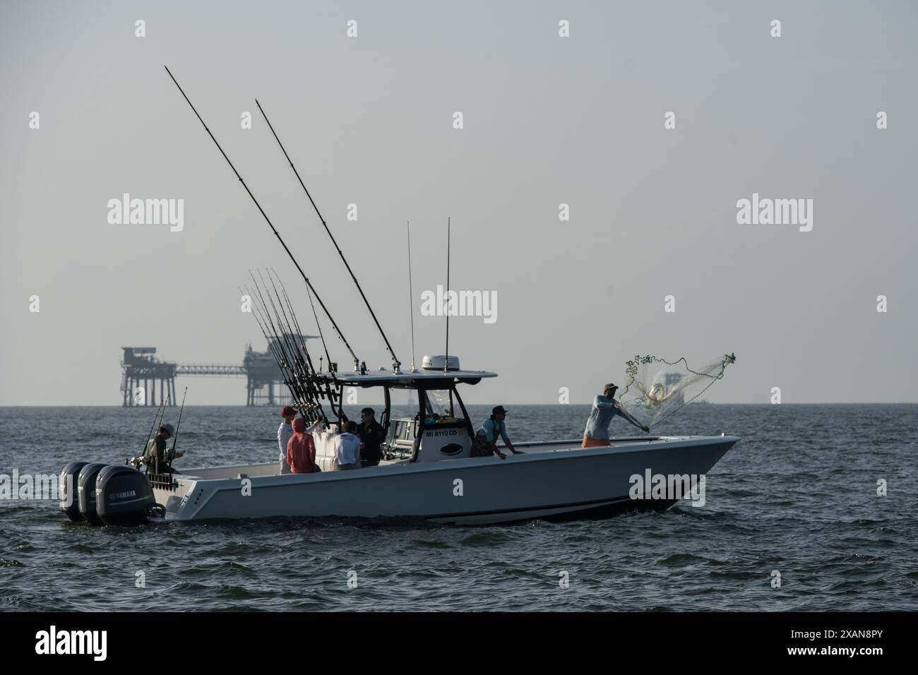 Anglers aboard a fishing boat near offshore oil rigs in the Gulf of ...