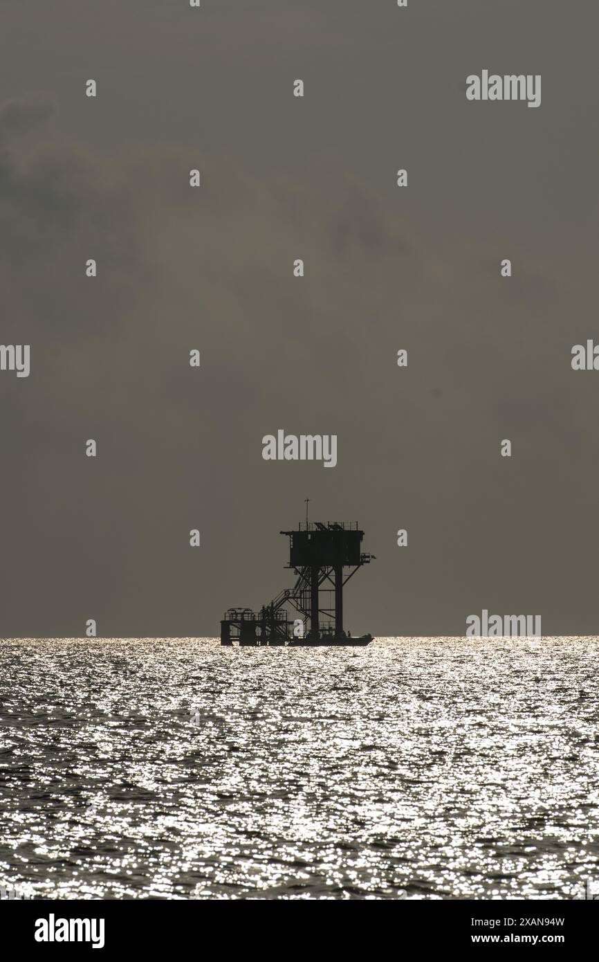Anglers aboard a fishing boat target tuna near a large floating oil ...