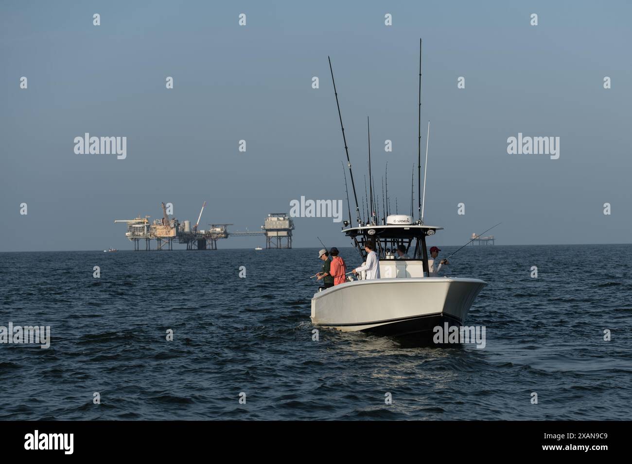 Anglers aboard a fishing boat near offshore oil rigs in the Gulf of ...