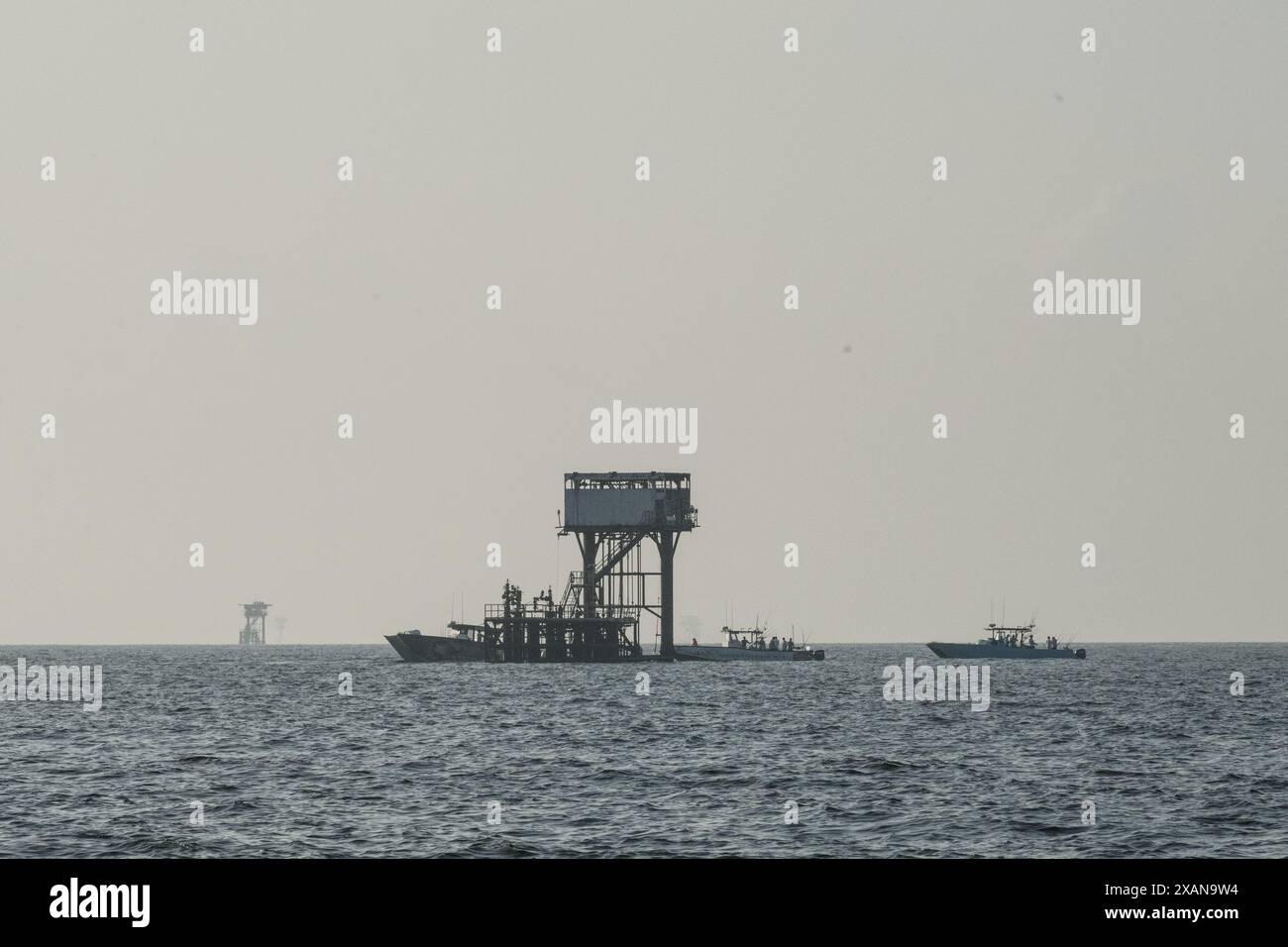 Anglers aboard a fishing boat near offshore oil rigs in the Gulf of ...