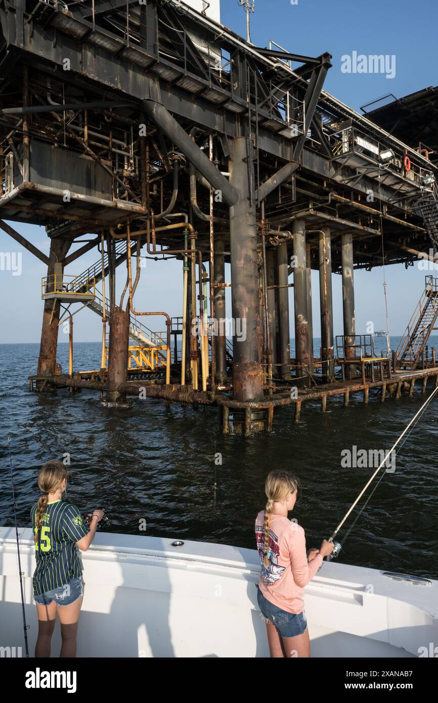 Anglers fish for baitfish while surrounded by offshore oil platforms in ...