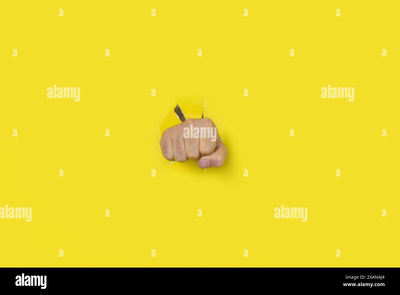 Fist punch through yellow paper background. Concept of aggression ...