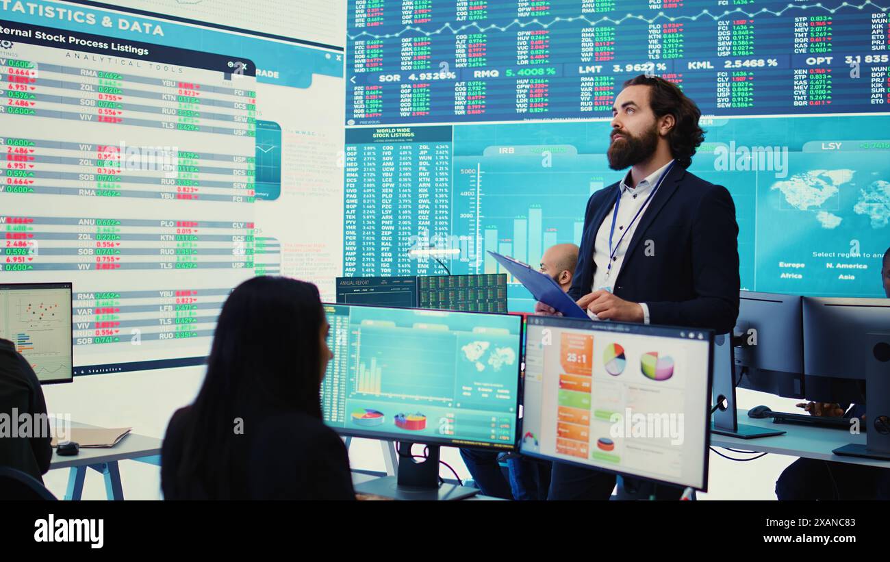 Chief executive officer reviews data shown on big display in the office ...