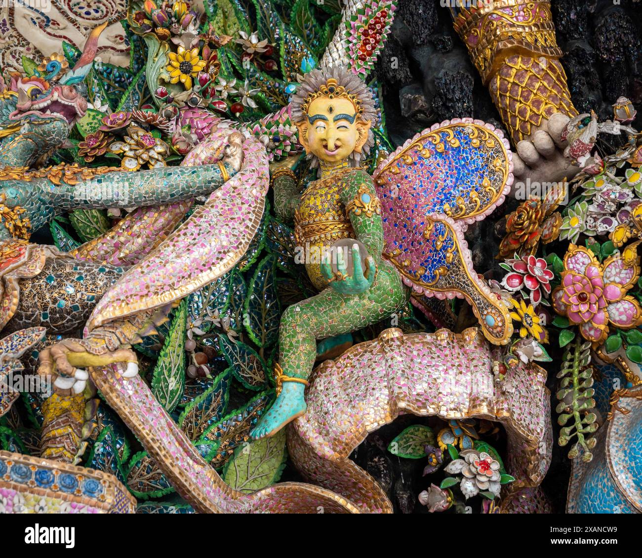 A close-up of a mythical creature sculpture with mosaics, on the wall ...