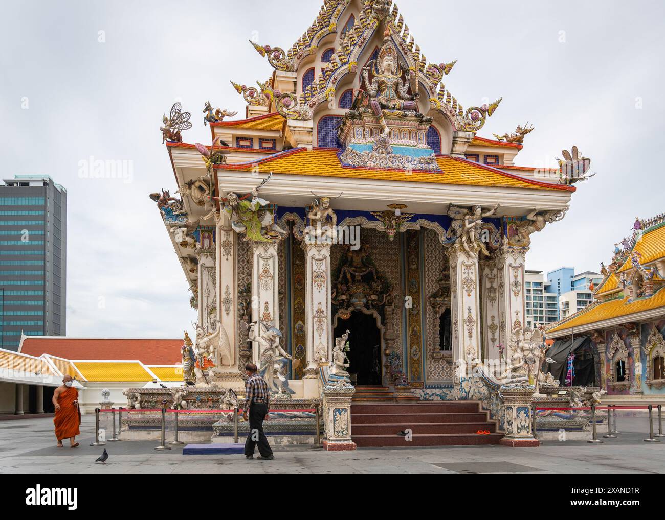 A view of the entrance of Wat Pariwat Temple, with a monk and a man ...