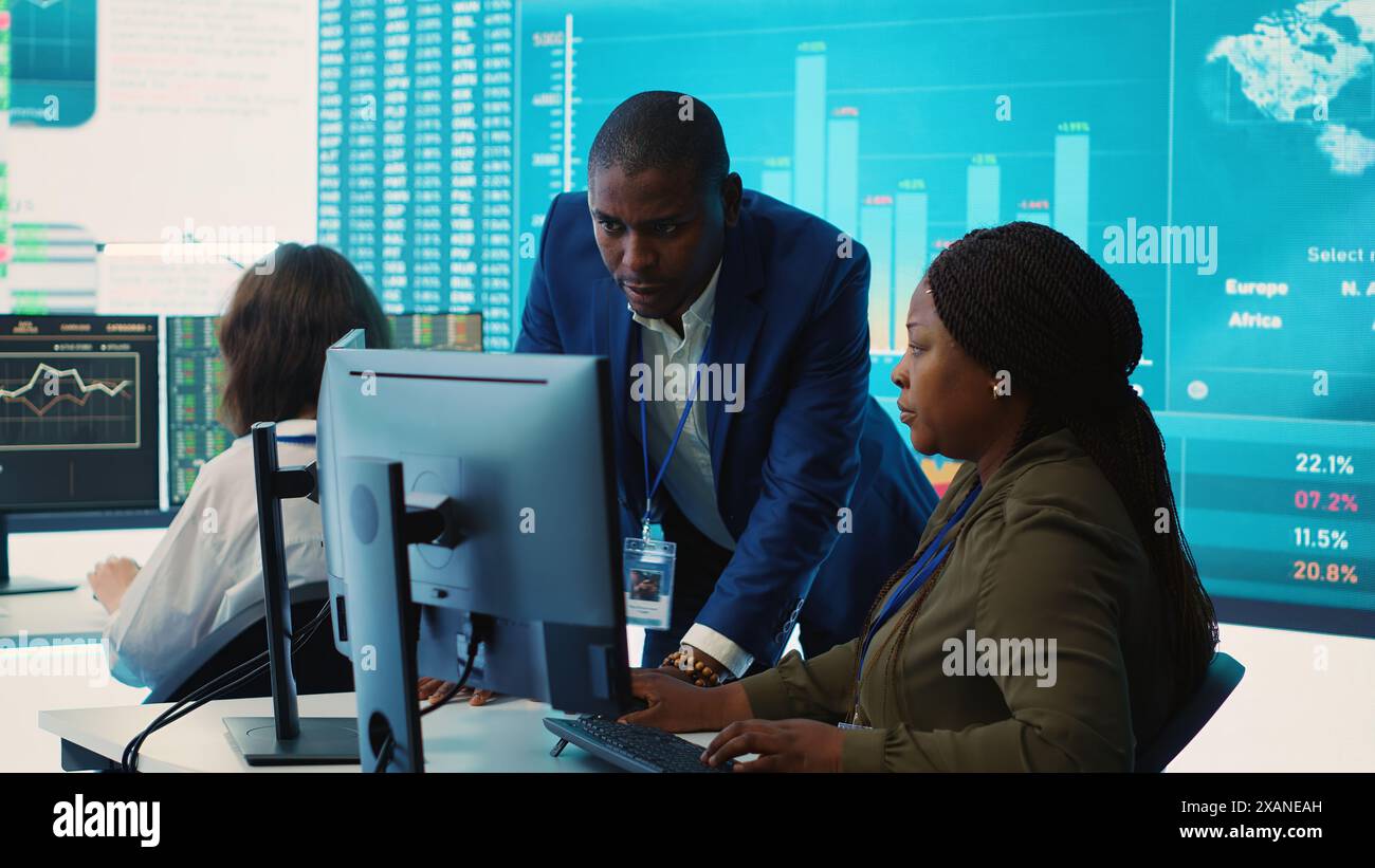 Financial analyst works on resource allocation plans with his staff, analyzing reports and sales ...