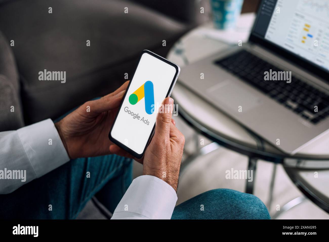 Man using a mobile phone with Google Ads on the screen and in the ...