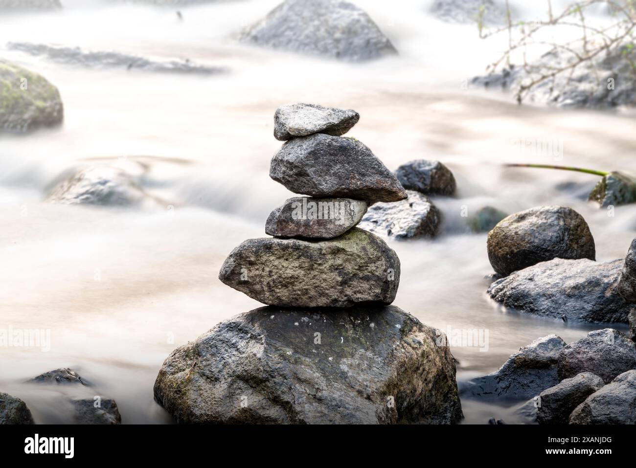 A stack of rocks is on top of a river. The rocks are large and the ...