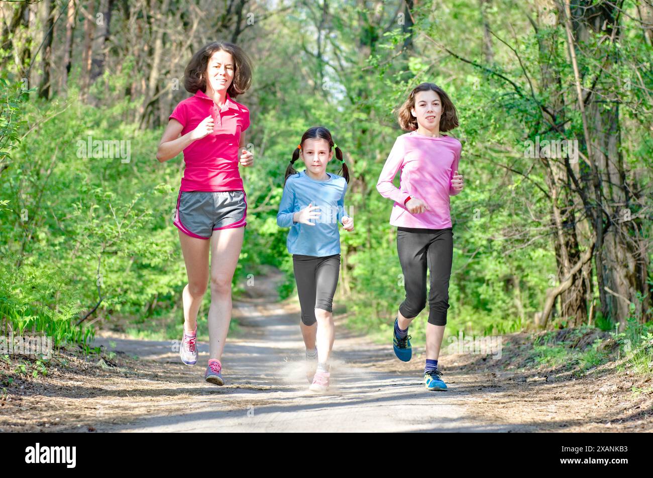 Family running, happy active mother and kids jogging outdoors, run with children in forest ...
