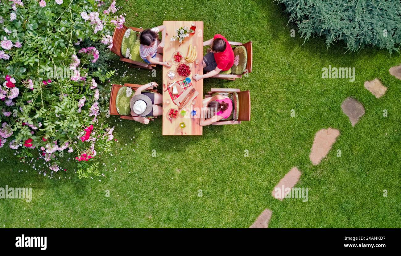 Family and friends eating together outdoors on summer garden party ...
