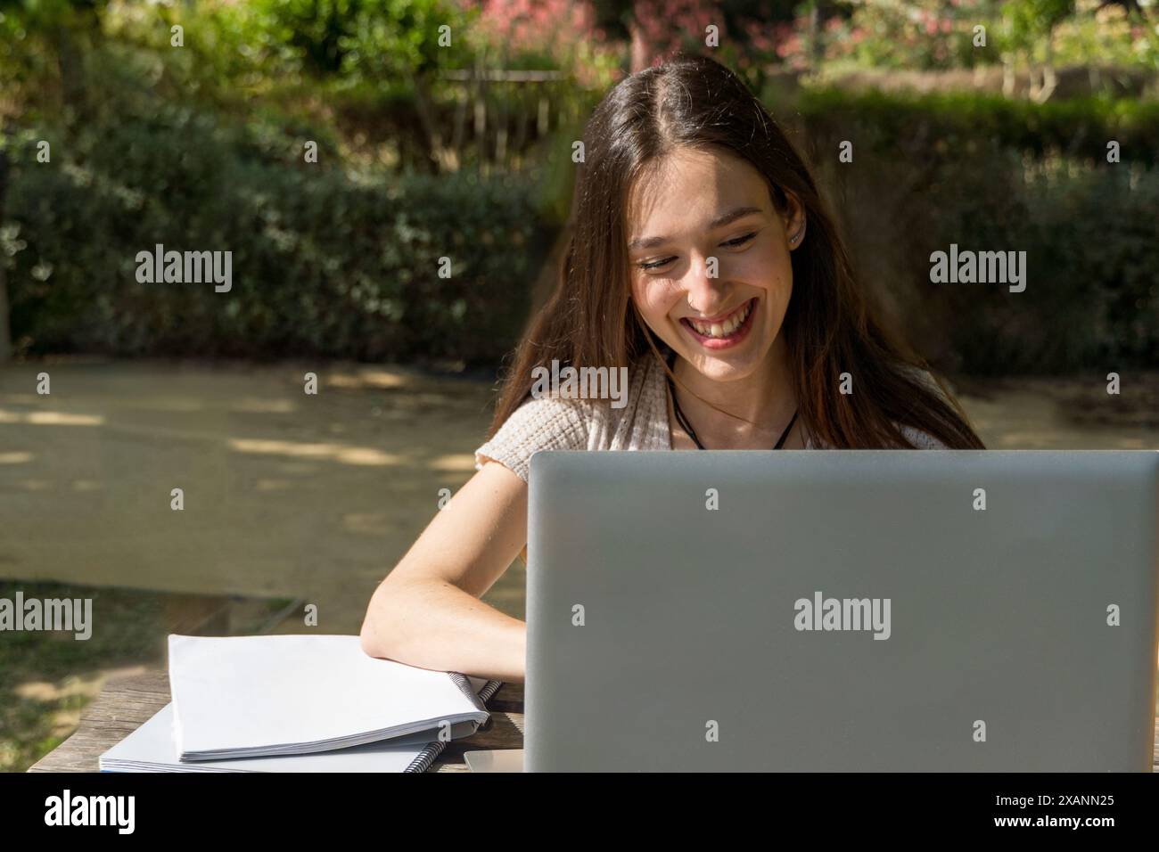 College student smiling while using her laptop on campus at the ...
