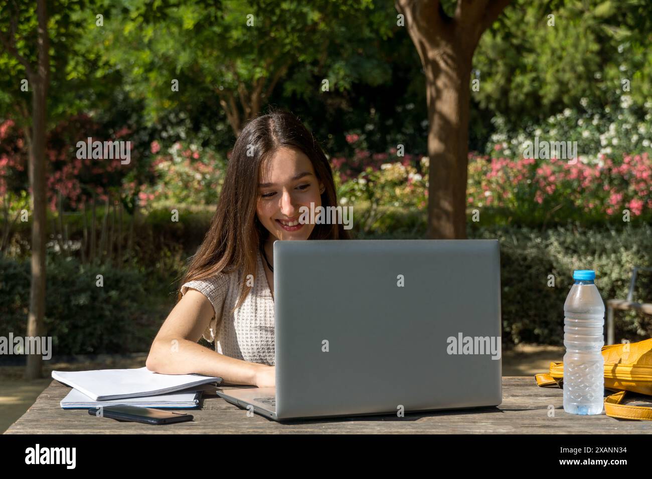 Young college girl sitting at a table on campus, participating in a ...