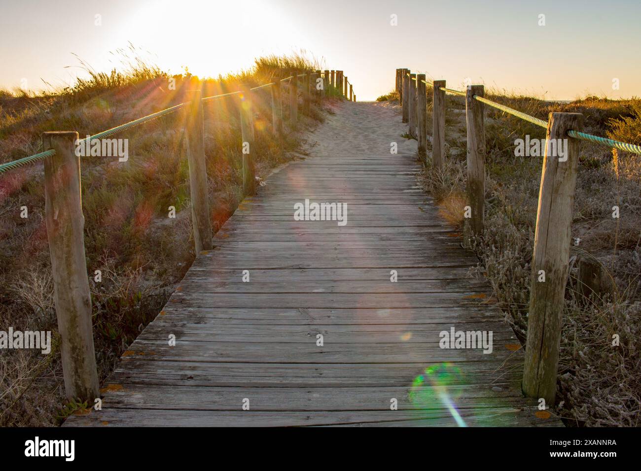 Wooden path with fence to the beach. Walkway on seashore in the morning ...
