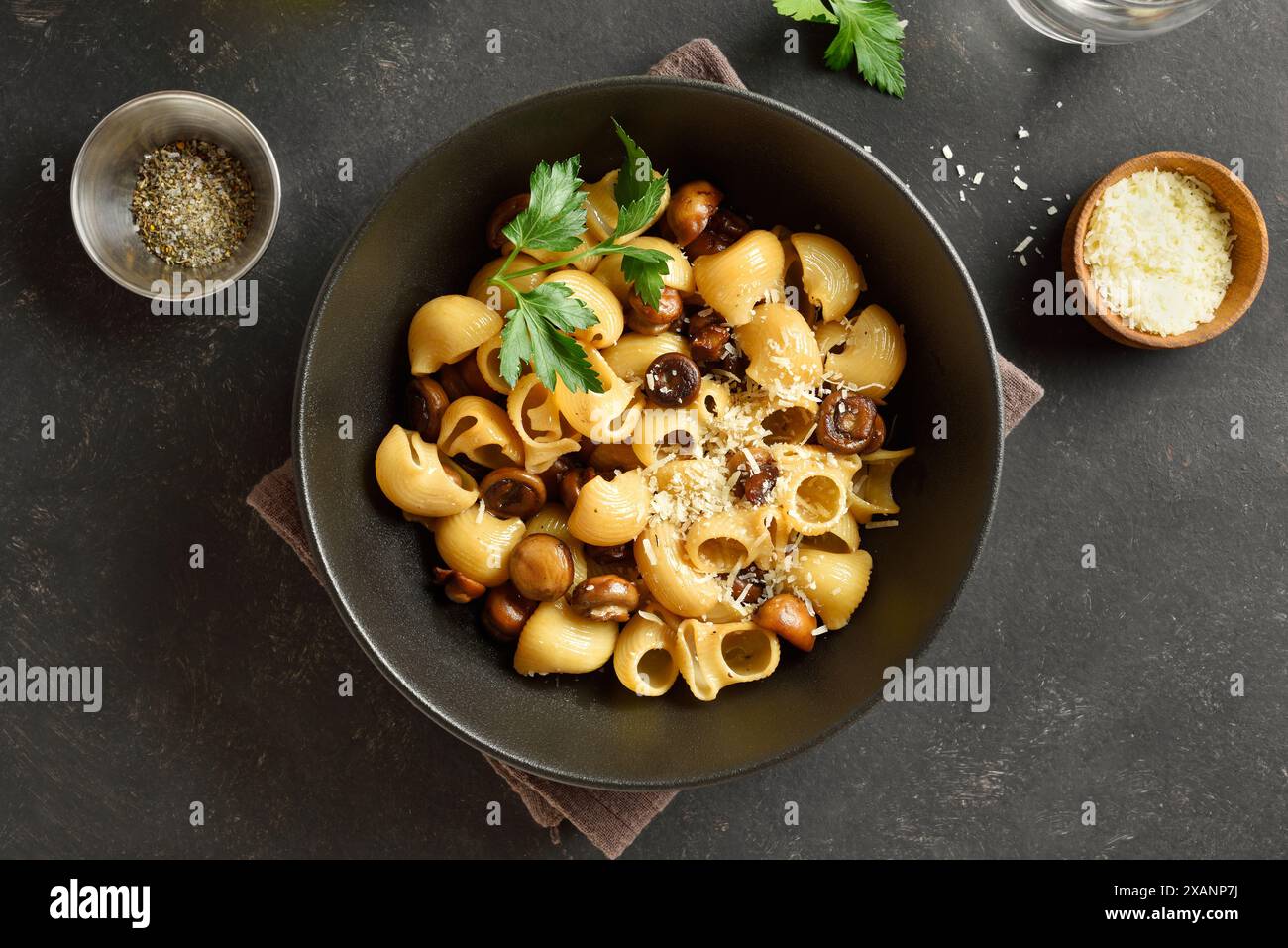 Pipe rigate pasta with roasted mushrooms served in black bowl on dark ...