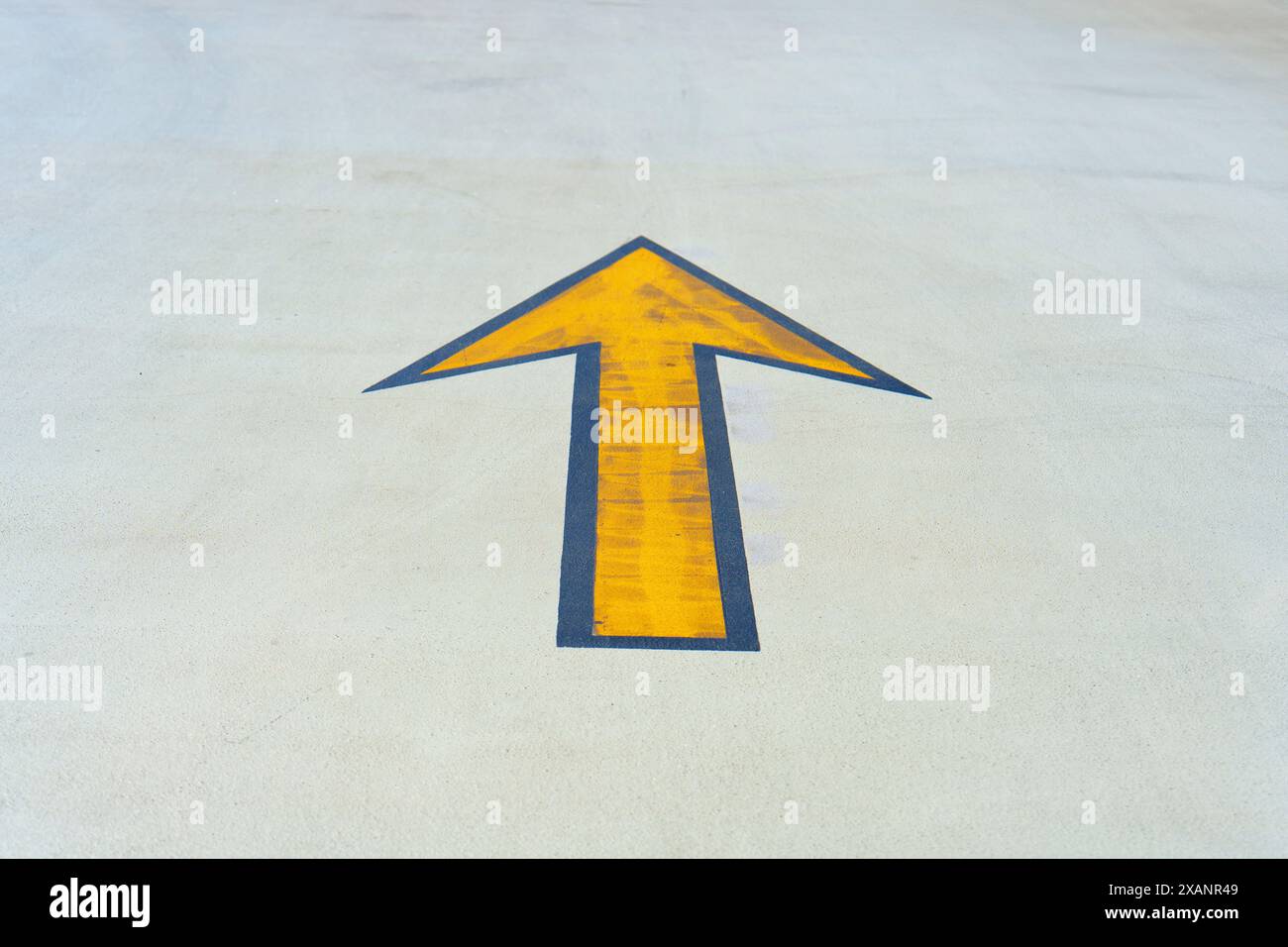 Vibrant yellow arrow, directing forward, artistically painted on a ...