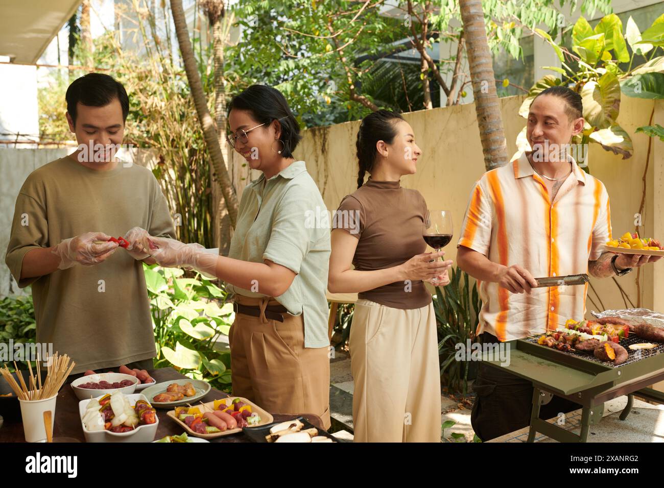 Group of people enjoying barbeque party with wine and delicious food ...