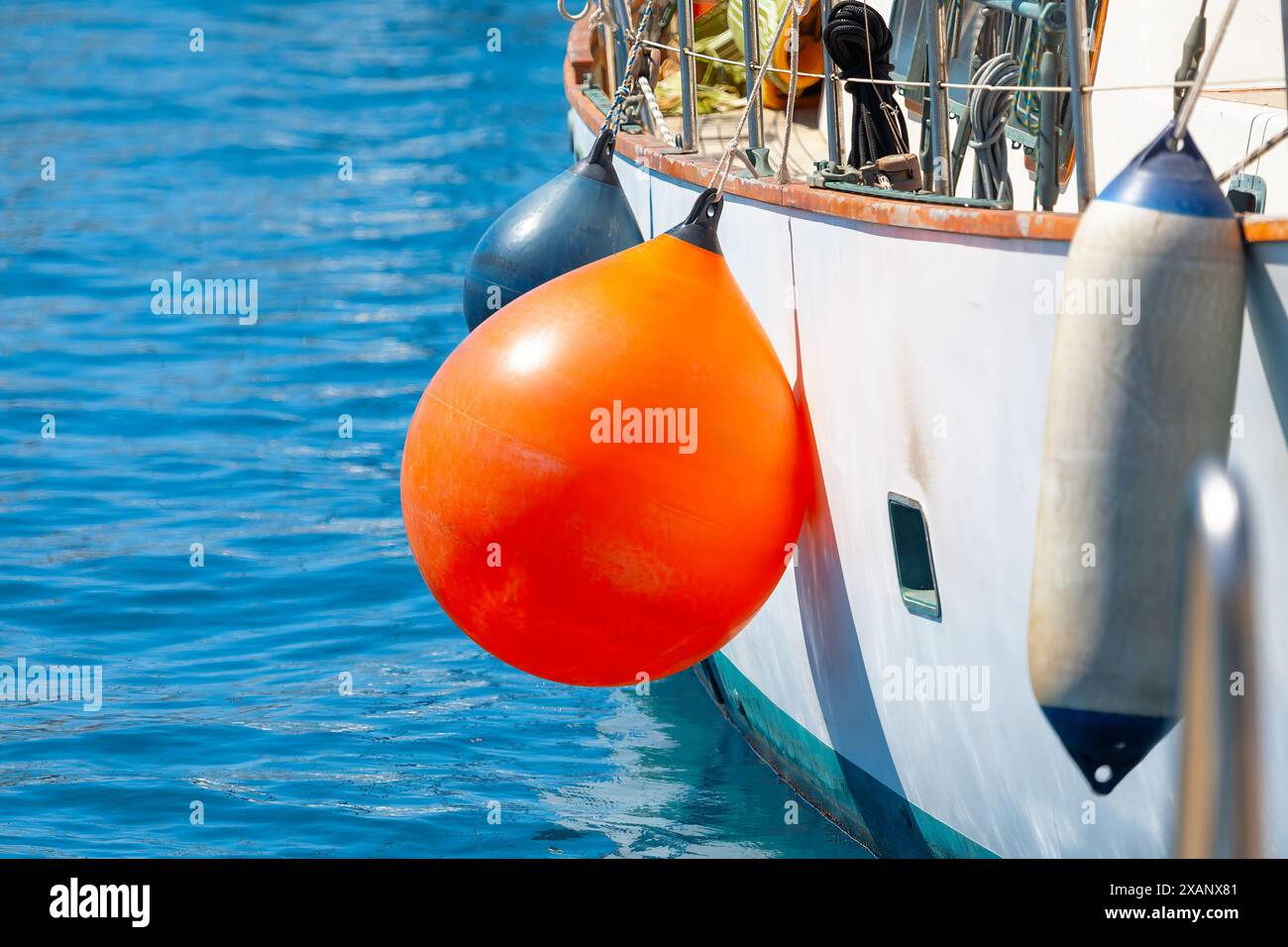Boat with red fenders floating in calm waters Stock Photo - Alamy