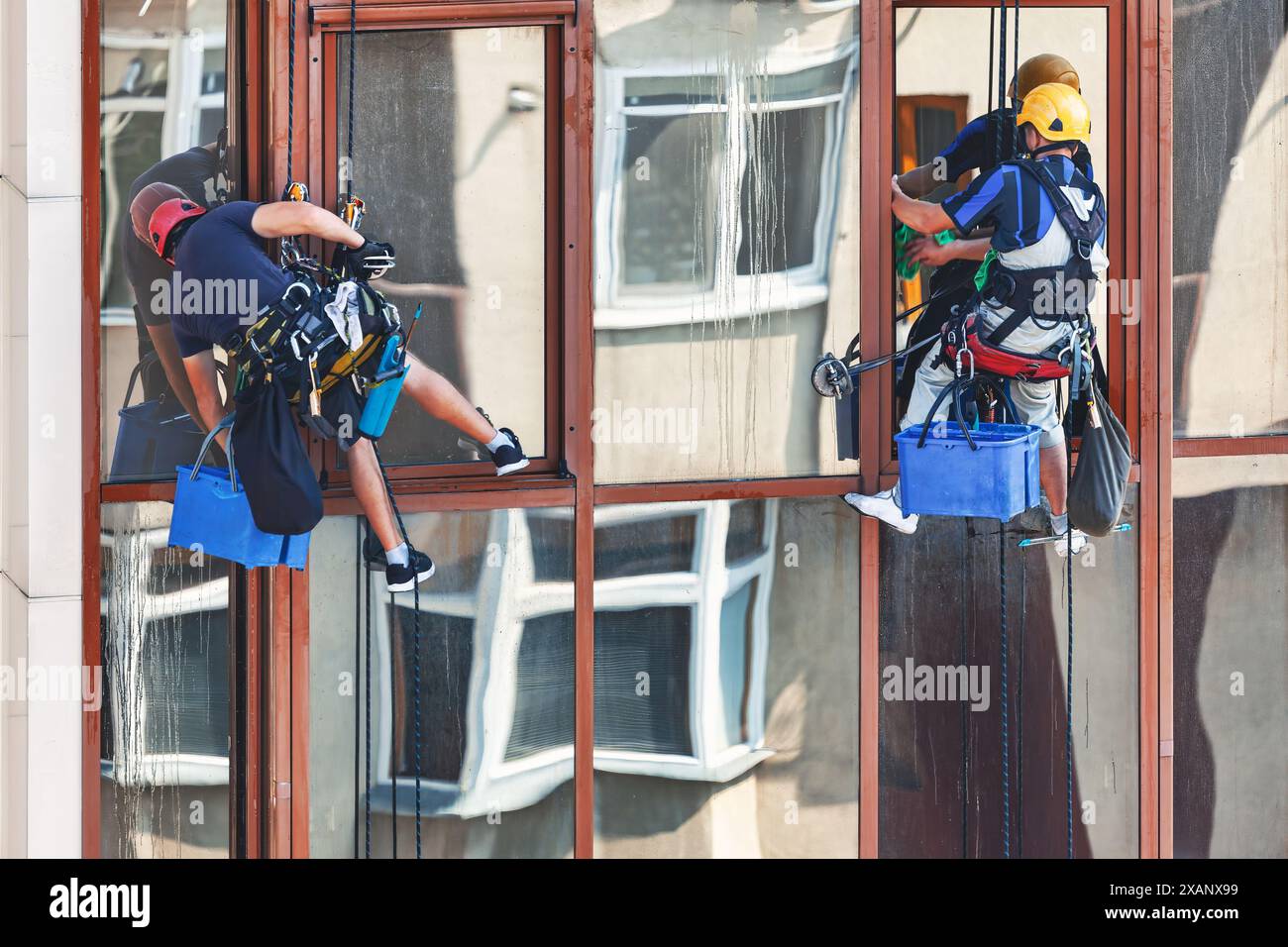 Two window washers cleaning the windows of a high-rise building Stock ...