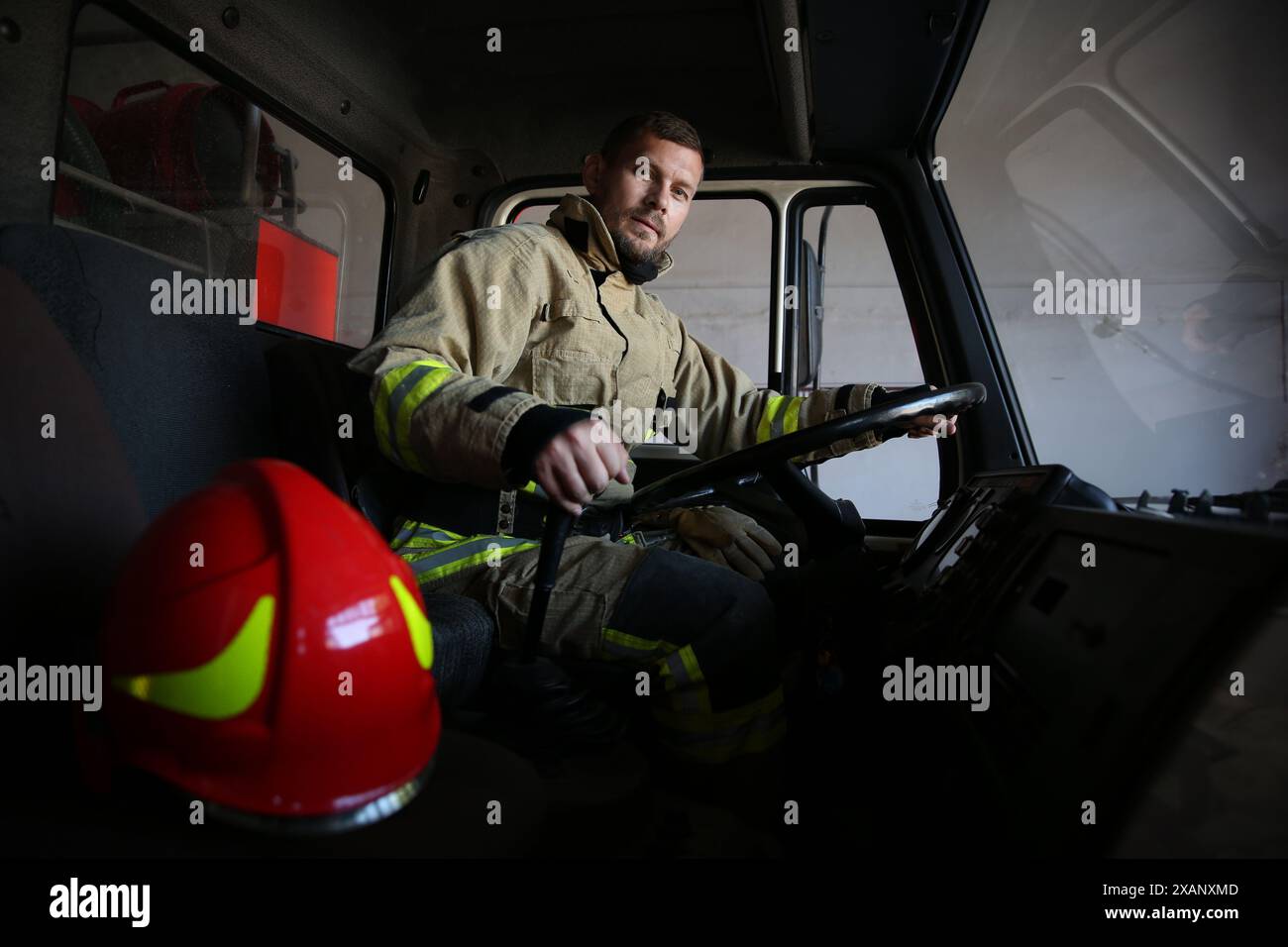 Firefighter in uniform driving modern fire truck Stock Photo - Alamy