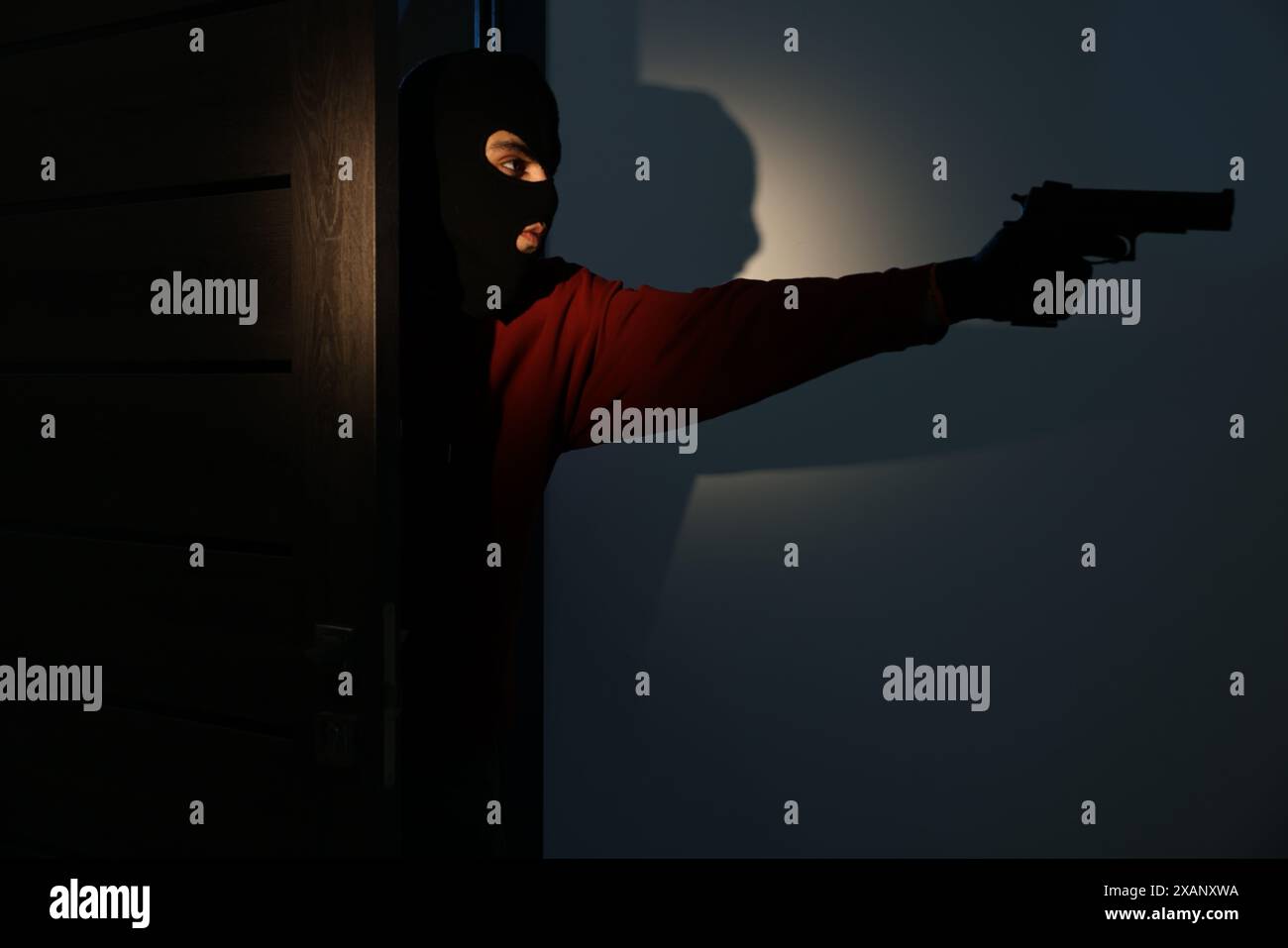 Thief with gun entering foreign house at night. Burglary Stock Photo ...