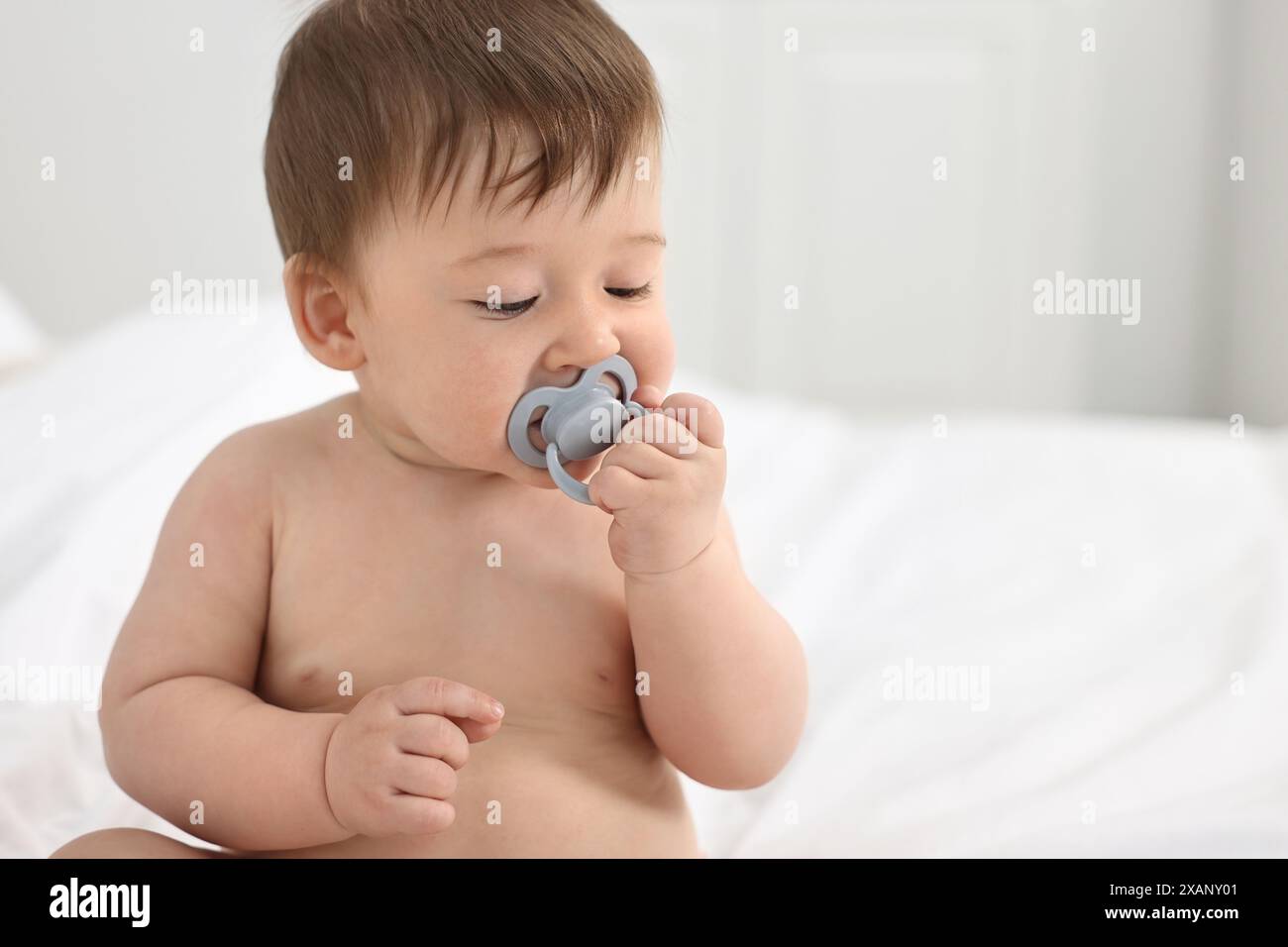 Cute baby boy with pacifier on bed at home Stock Photo - Alamy