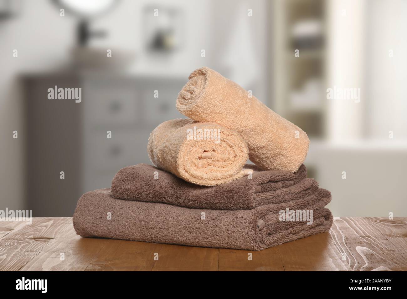 Stack of fresh towels on table against blurred bathroom interior Stock ...