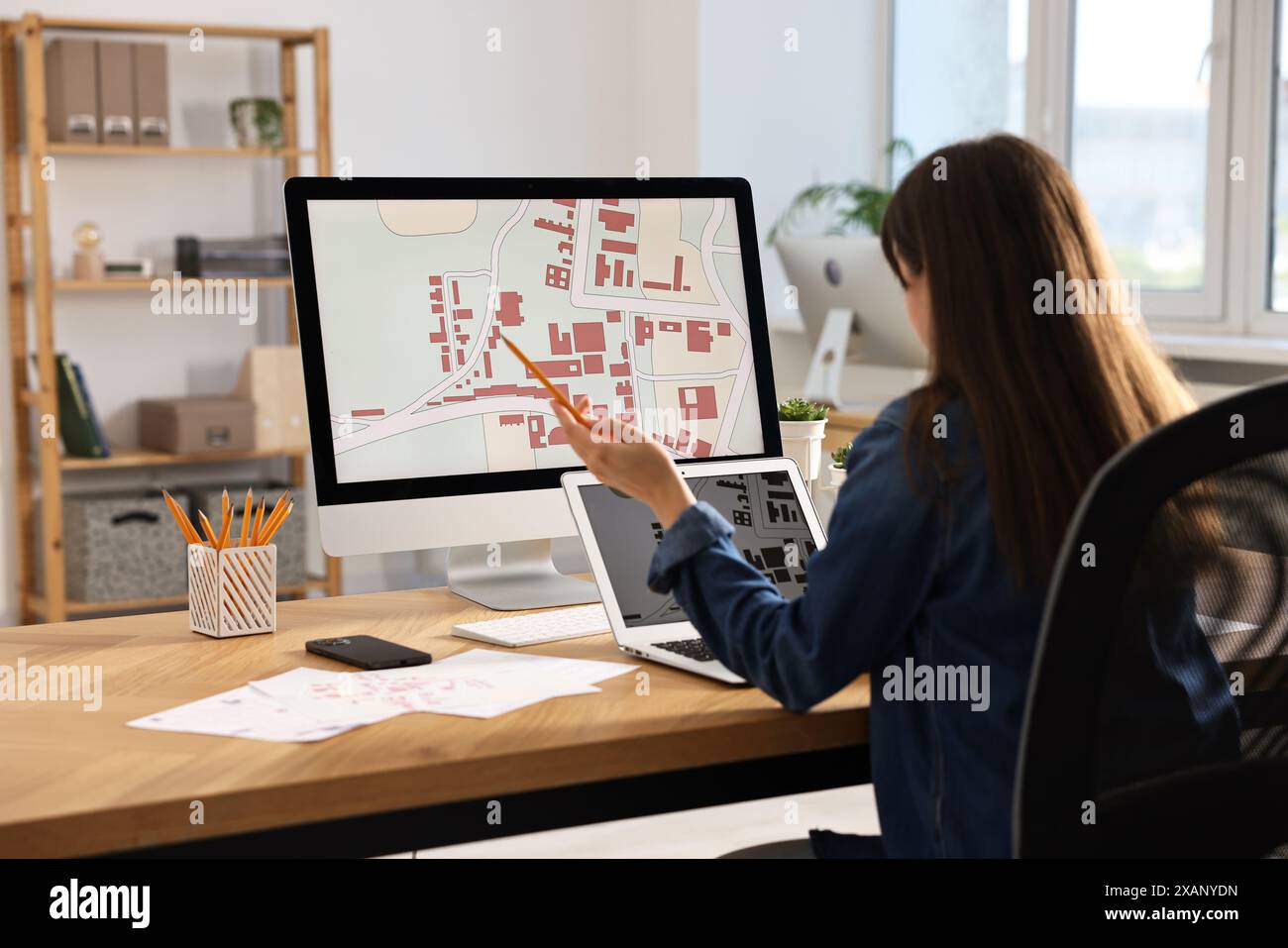 Cartographer working with cadastral maps at table in office Stock Photo ...