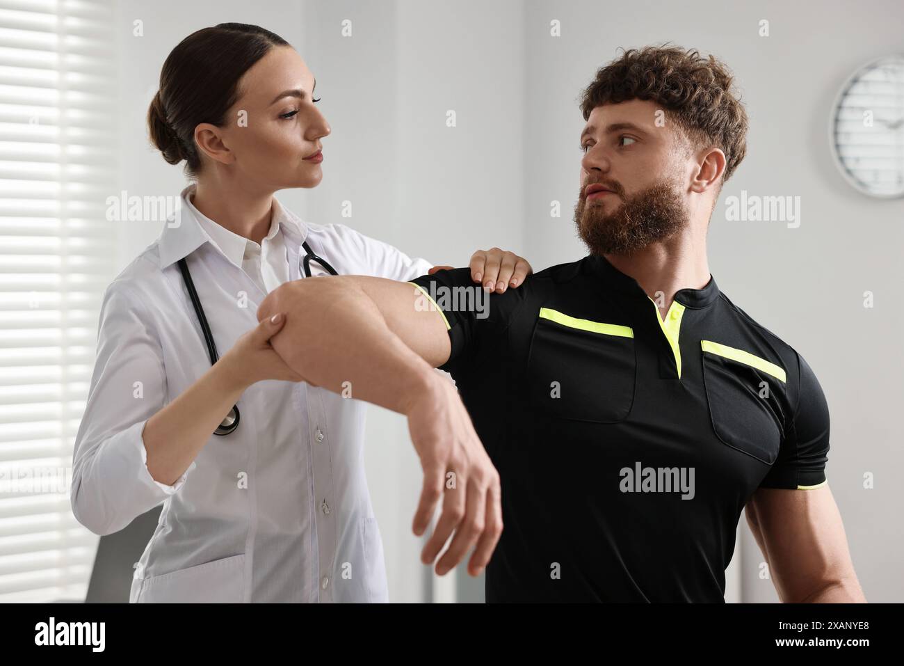 Sports injury. Doctor examining patient's shoulder in hospital Stock ...