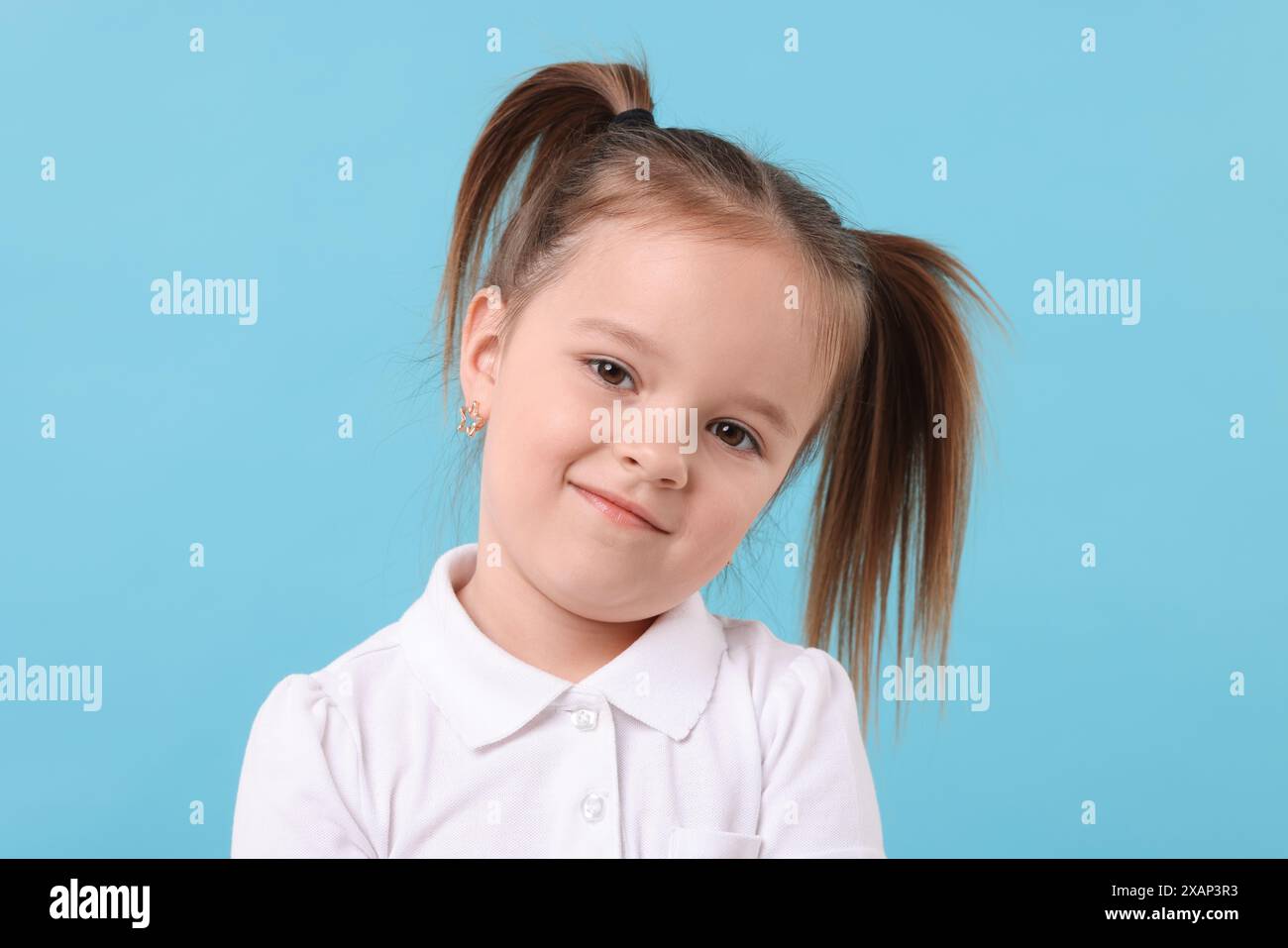 Portrait of cute little girl on light blue background Stock Photo - Alamy