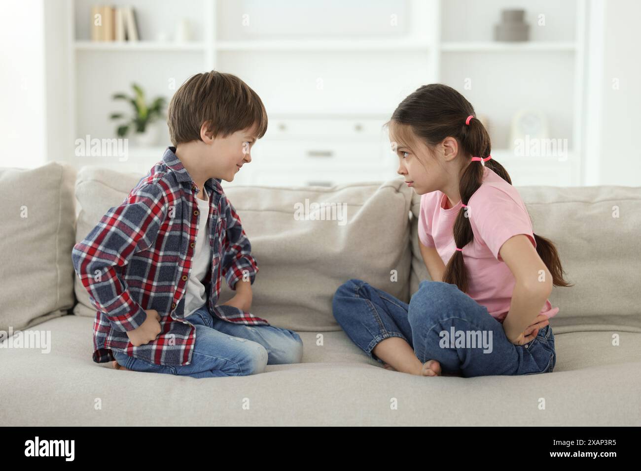 Upset brother and sister having argument on sofa at home Stock Photo ...