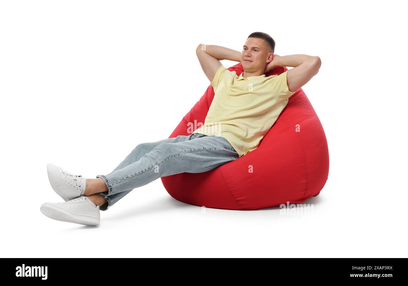 Handsome man resting on red bean bag chair against white background ...